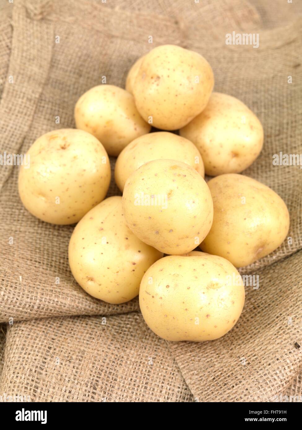 Freshly grown potatos isolated on hessian Stock Photo - Alamy