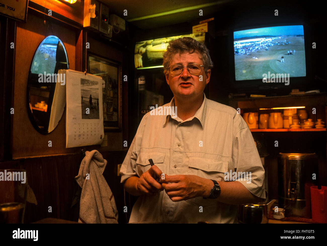 Edward Gaughan in his bar cleaning and filling a pipe. Ballina, County ...