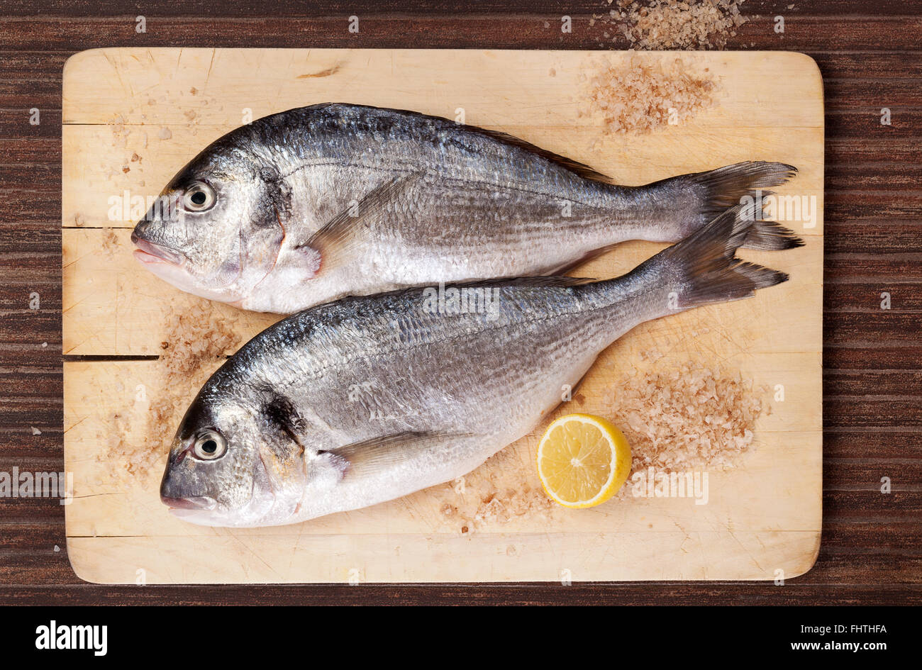 Two fish on wooding kitchen board Stock Photo - Alamy