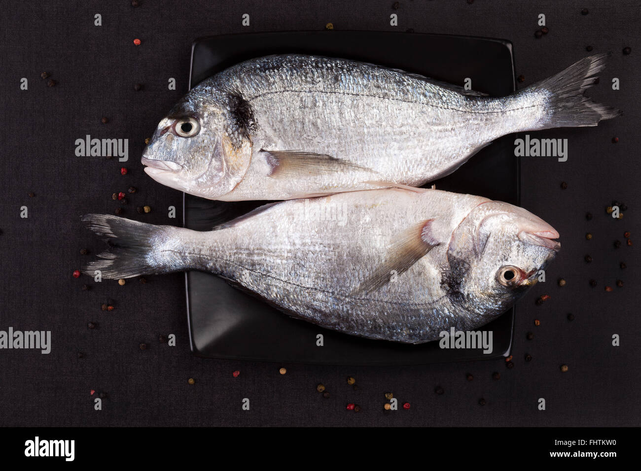 Luxurious fish on black plate Stock Photo - Alamy
