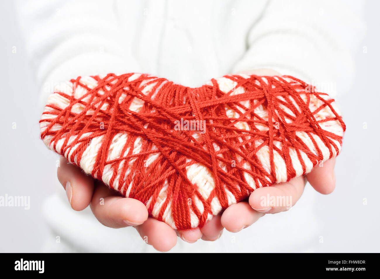 Woman hands giving a knitted heart. A symbol of valentines day and love ...
