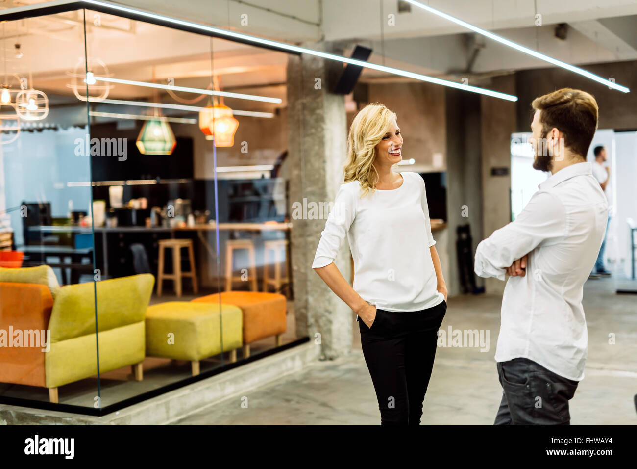 Beautiful saleswoman talking to customer and smiling Stock Photo - Alamy