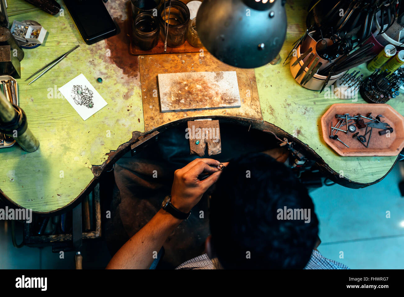 Goldsmith working on his bench, crafting jewelry Stock Photo - Alamy