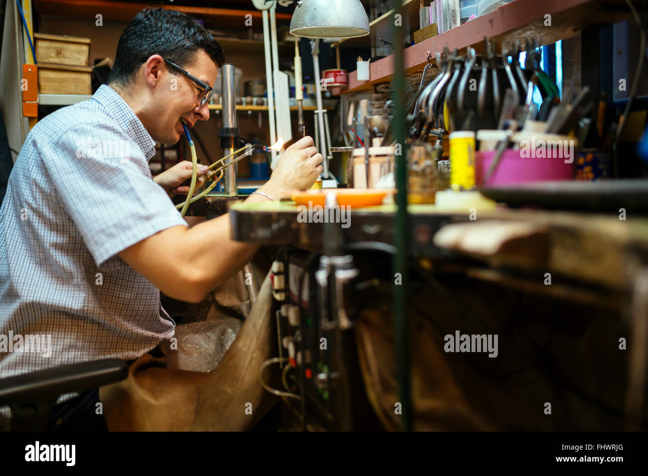 Goldsmith working and creating jewelry Stock Photo - Alamy