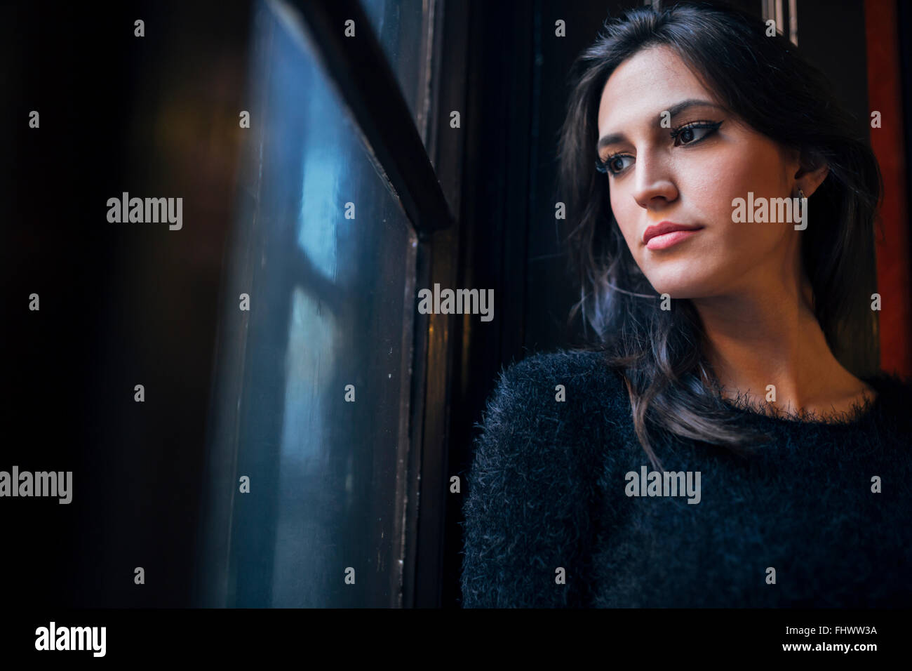 Pretty woman looking out the window Stock Photo - Alamy