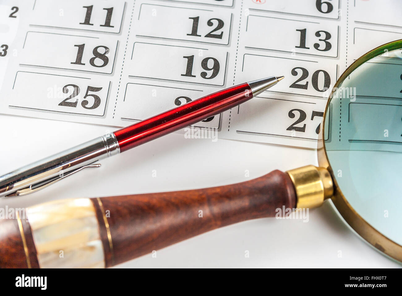Pen And Magnifying Glass On Calendar Stock Photo - Alamy
