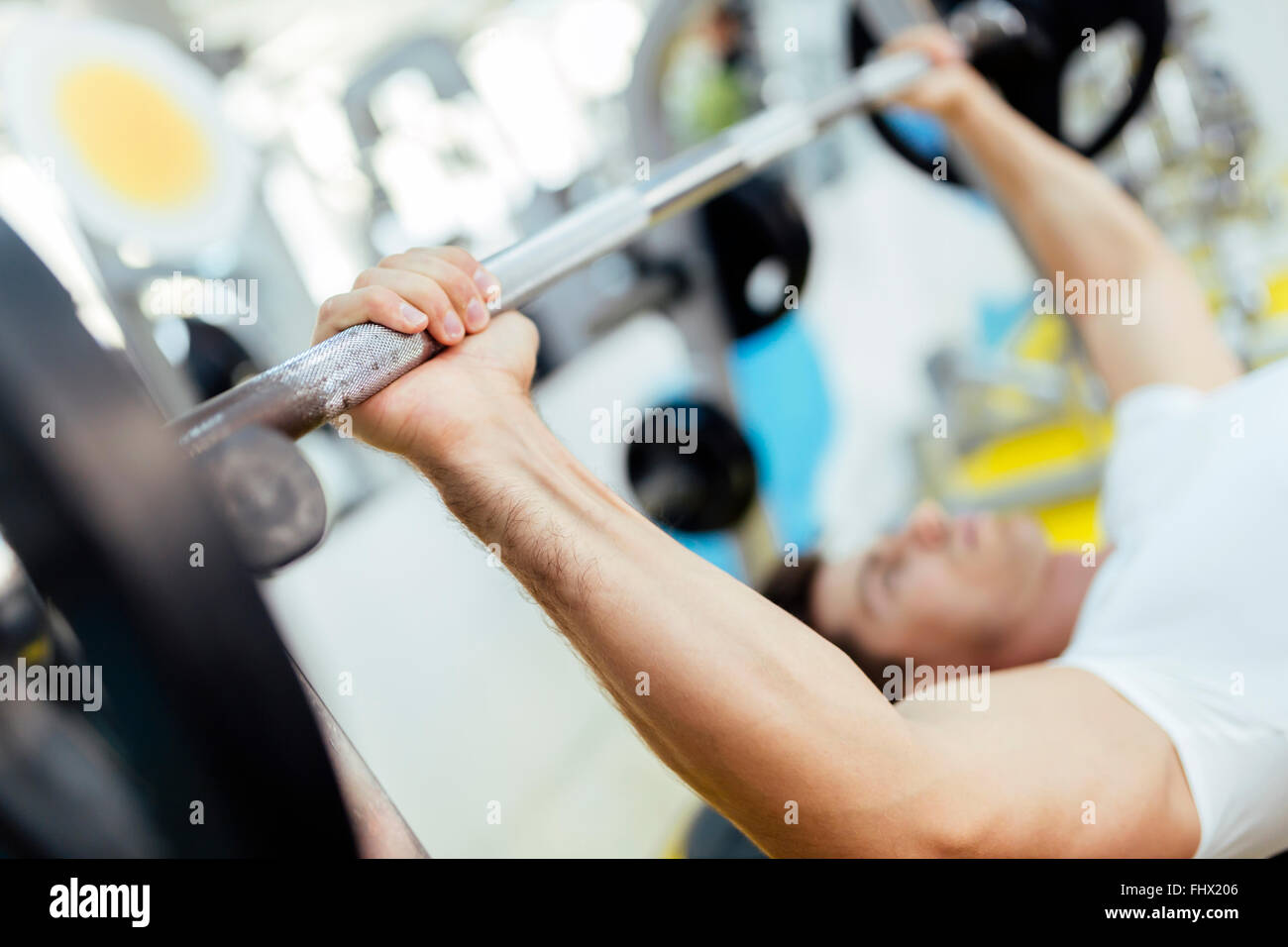 Handsome man lifting weights in gym and staying fit Stock Photo - Alamy