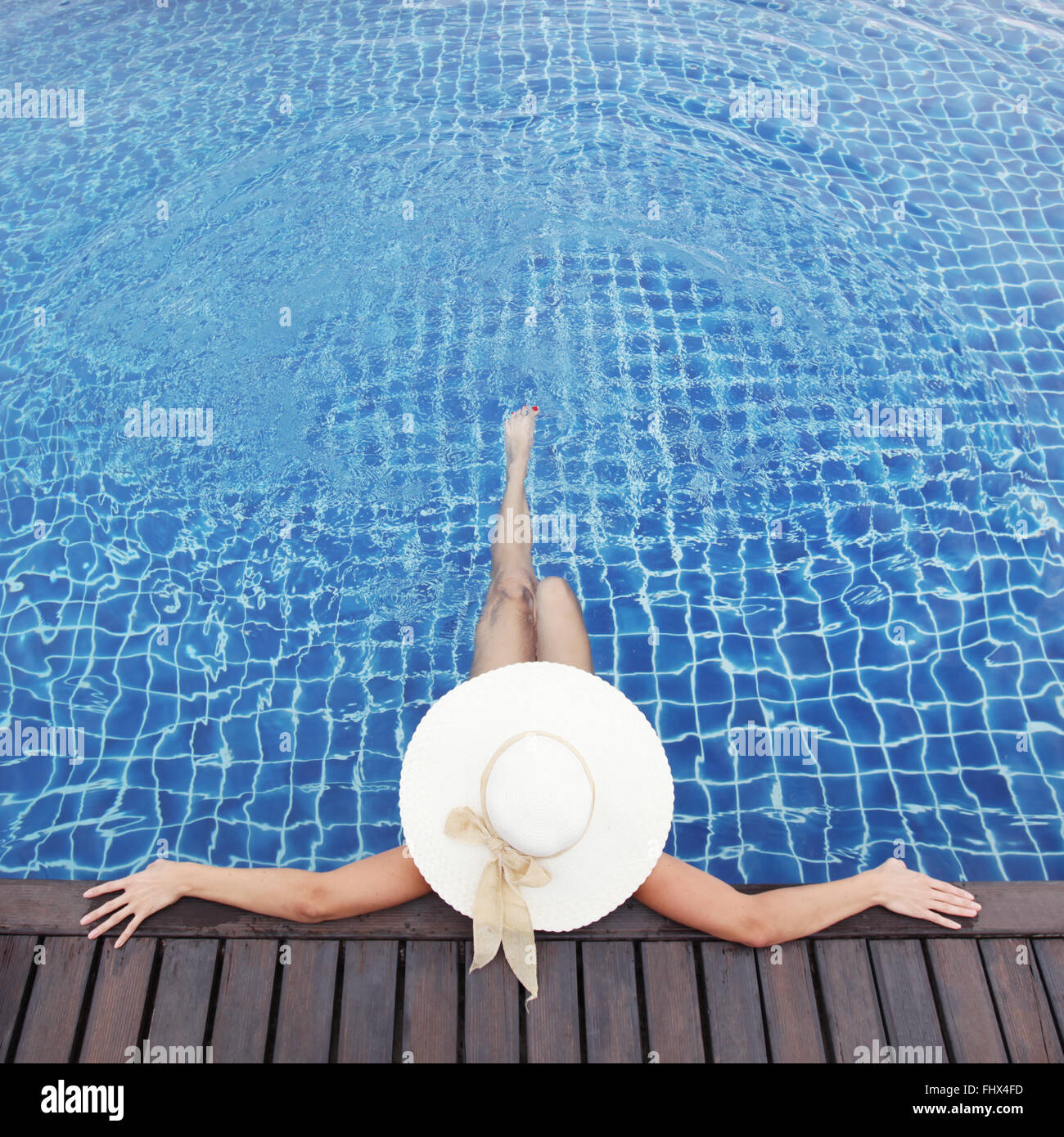 Woman in hat relaxing at the pool Stock Photo - Alamy