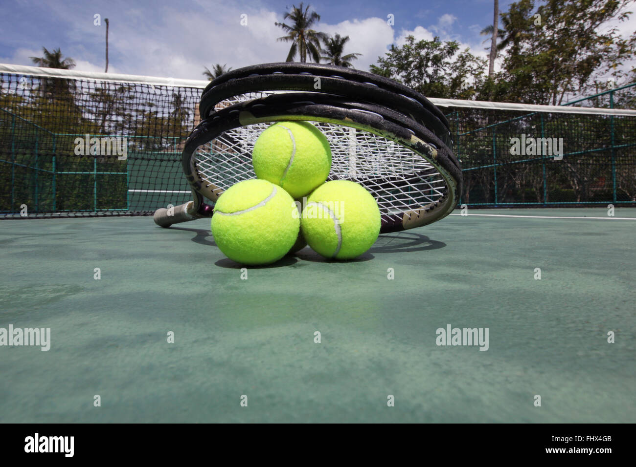 Tennis balls and racket on court close up Stock Photo - Alamy