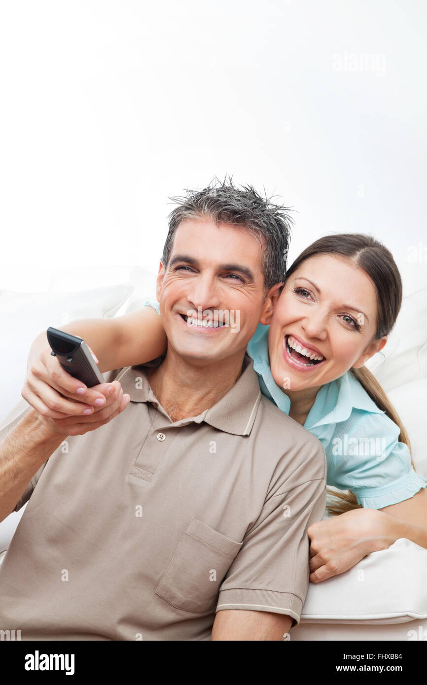 Happy couple watching TV with remote control at home Stock Photo - Alamy