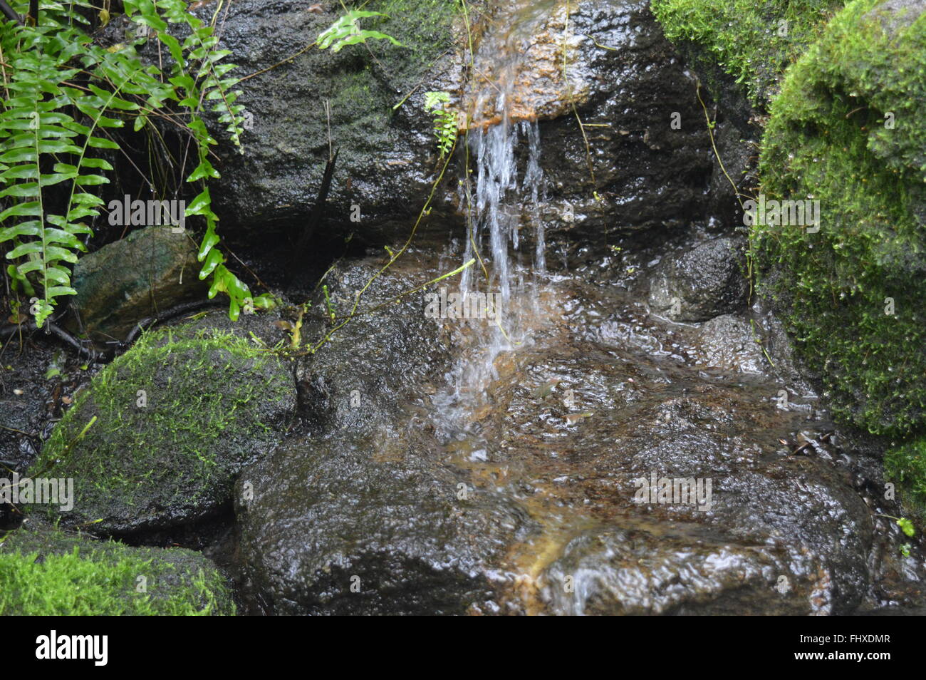 Small waterfall flowing over rocks Stock Photo - Alamy