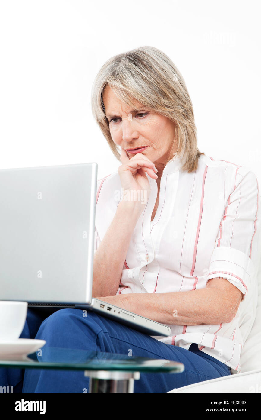 Frustrated senior woman with laptop at home on couch Stock Photo - Alamy