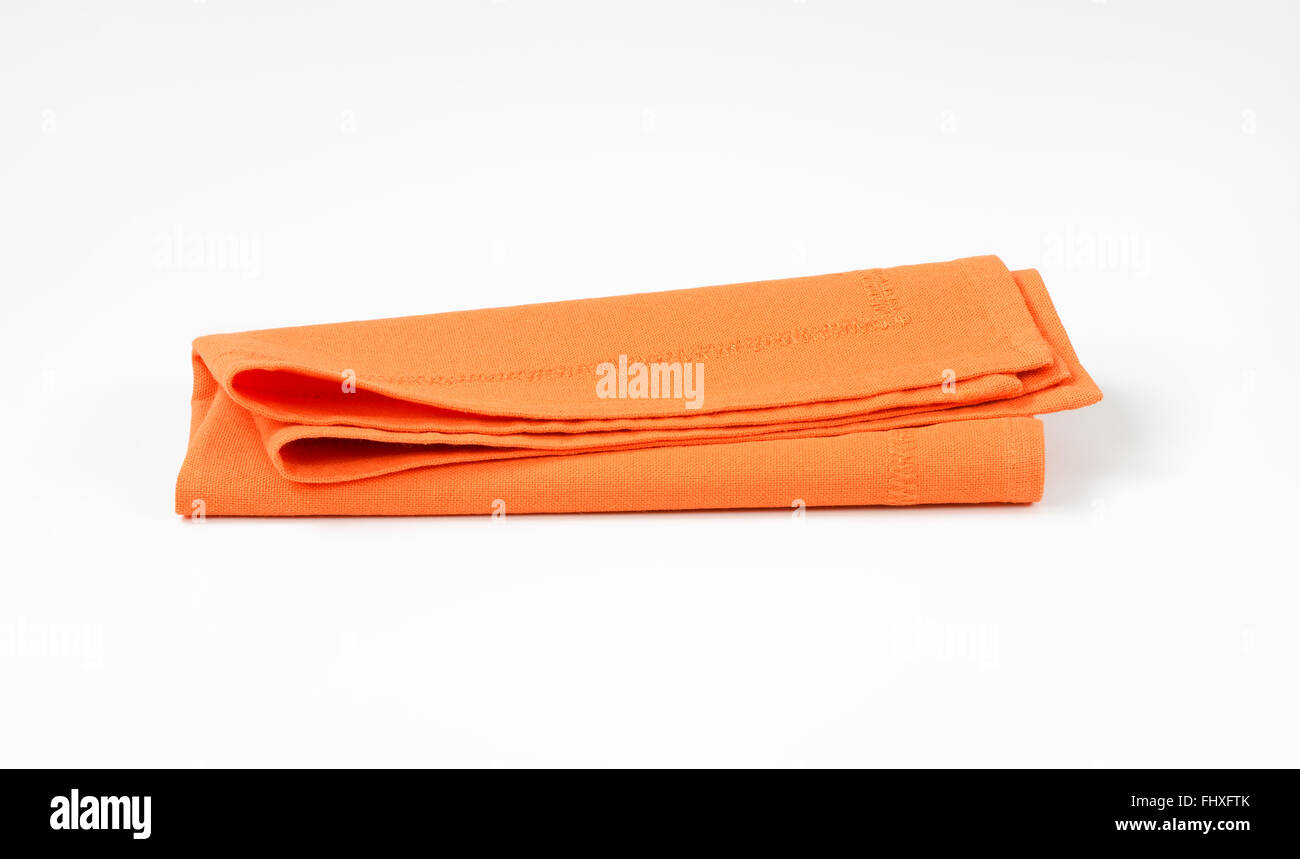 Orange napkin folded twice vertically Stock Photo - Alamy