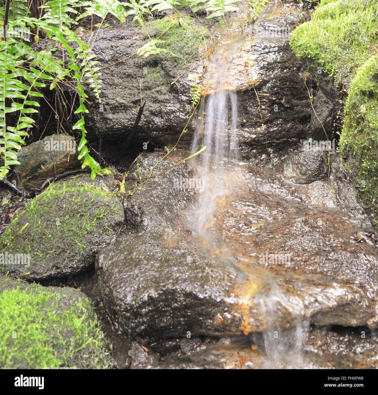 Small waterfall flowing over rocks Stock Photo - Alamy