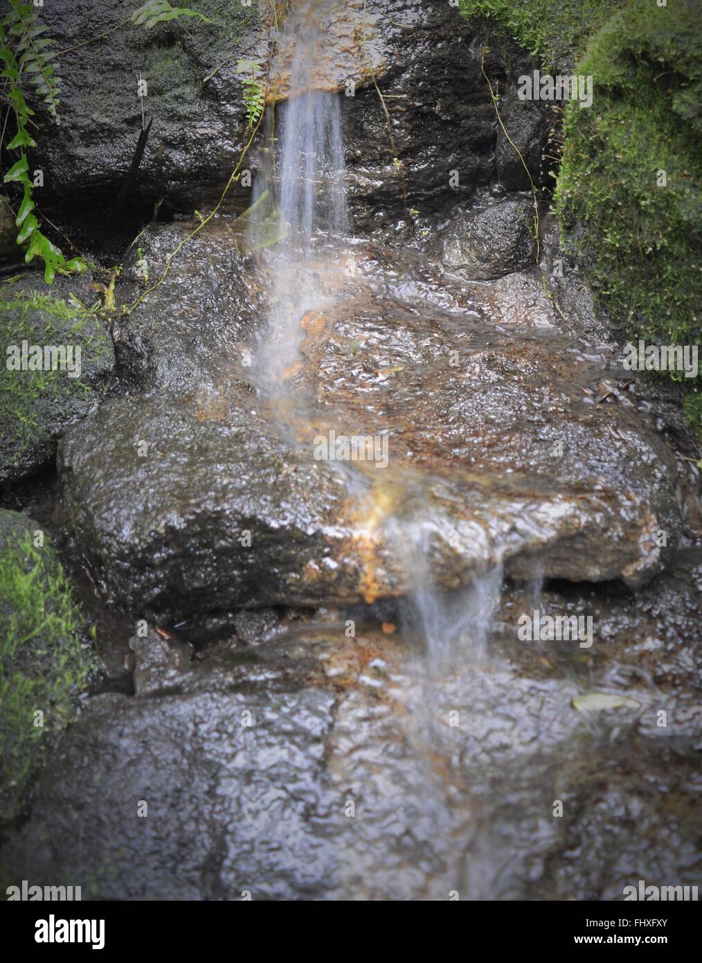 Small waterfall flowing over rocks Stock Photo - Alamy