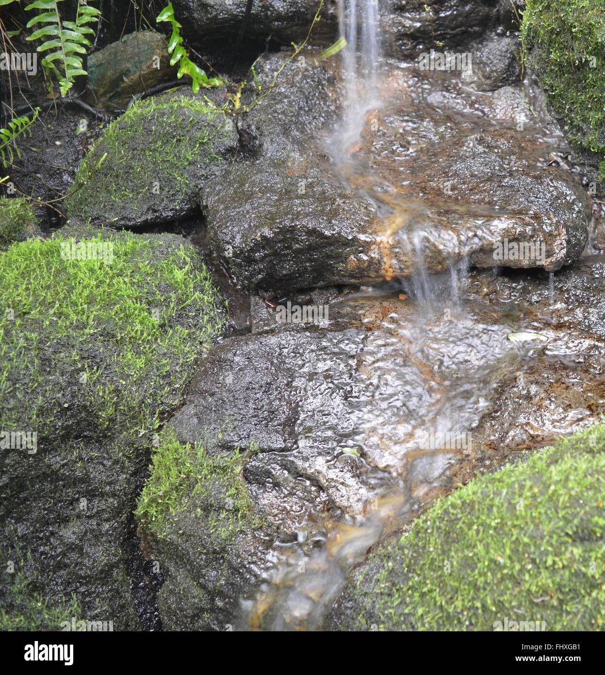 Small waterfall flowing over rocks Stock Photo - Alamy