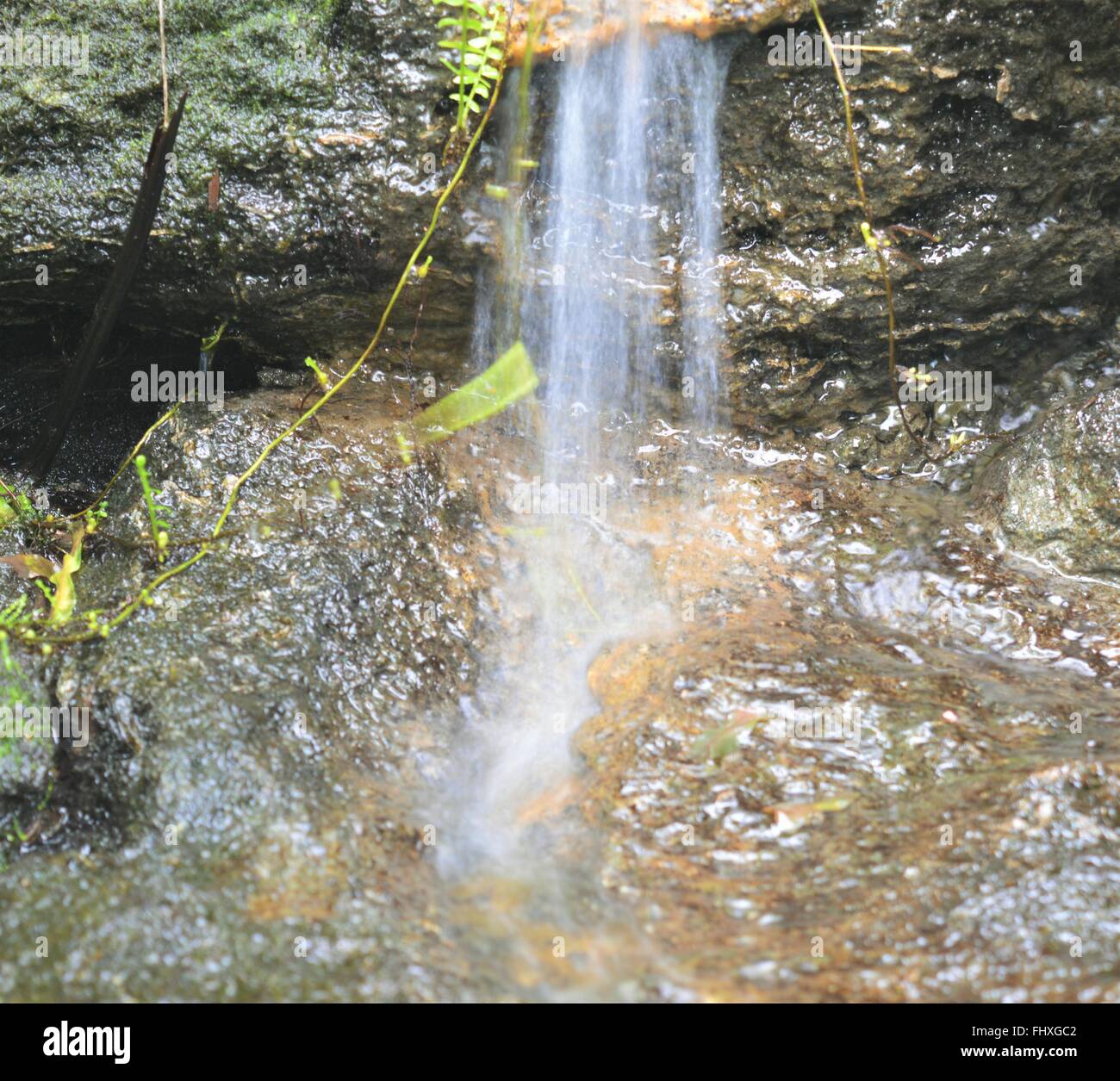 Small waterfall flowing over rocks Stock Photo - Alamy