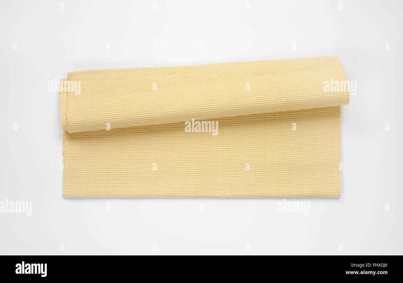 Folded beige cotton table mat on white background Stock Photo - Alamy