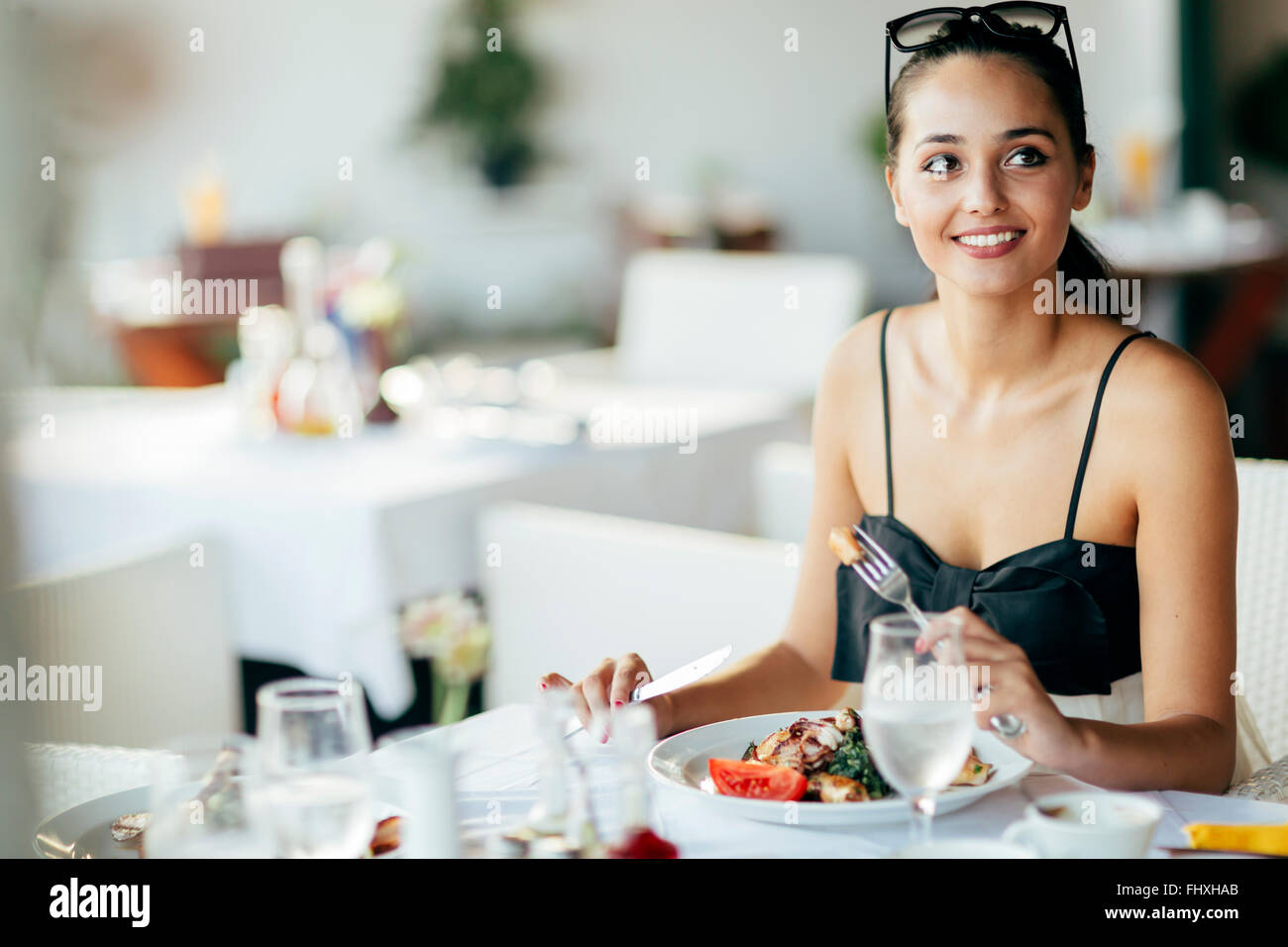 Beautiful woman eating meal in restaurant during sunset Stock Photo - Alamy