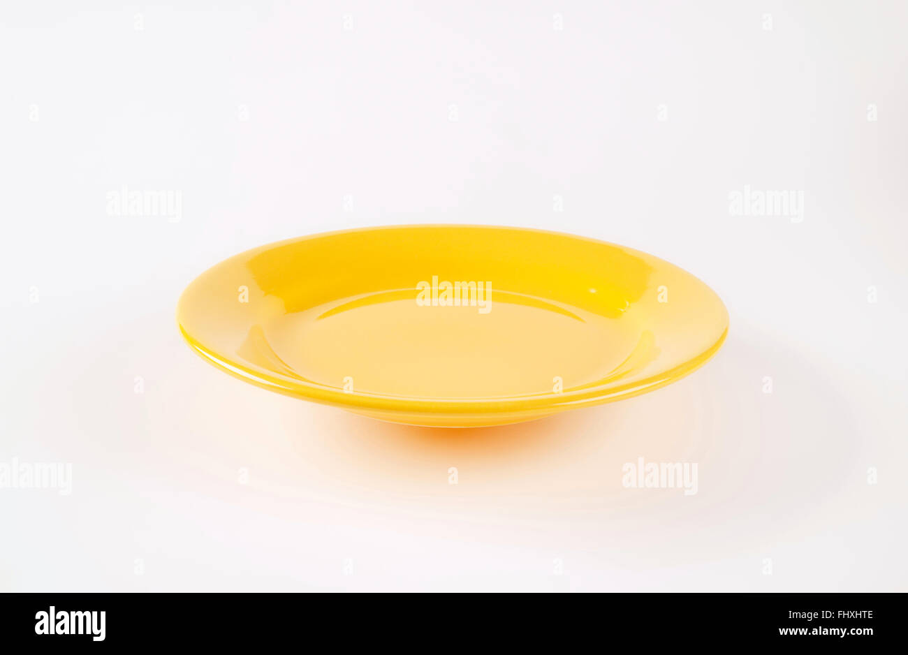 empty yellow plate on white background Stock Photo - Alamy