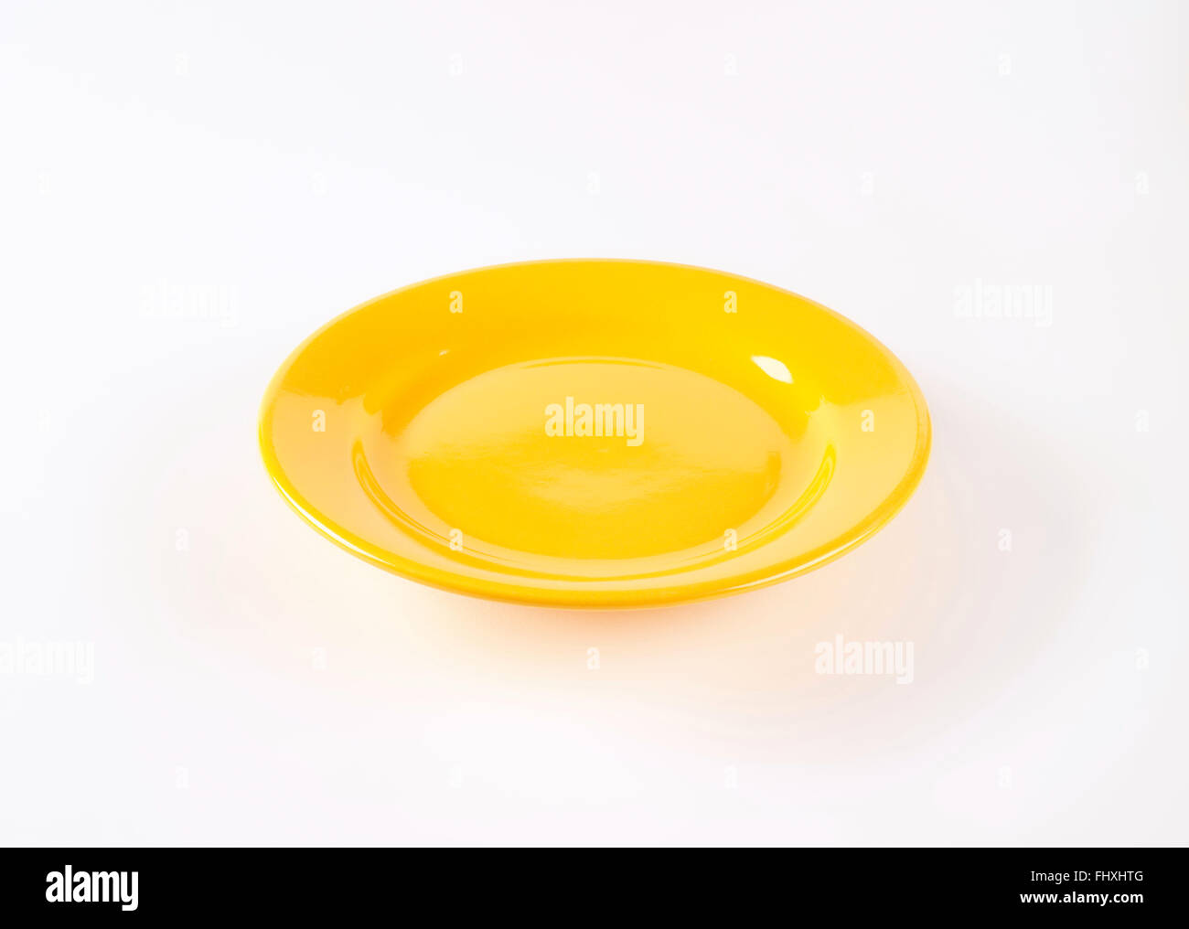 empty yellow plate on white background Stock Photo - Alamy