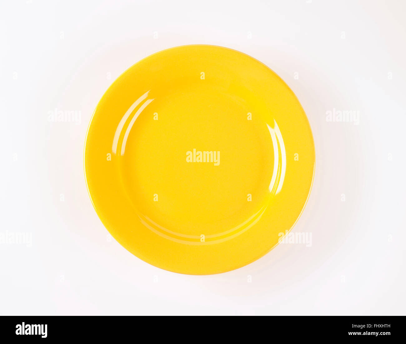 empty yellow plate on white background Stock Photo - Alamy