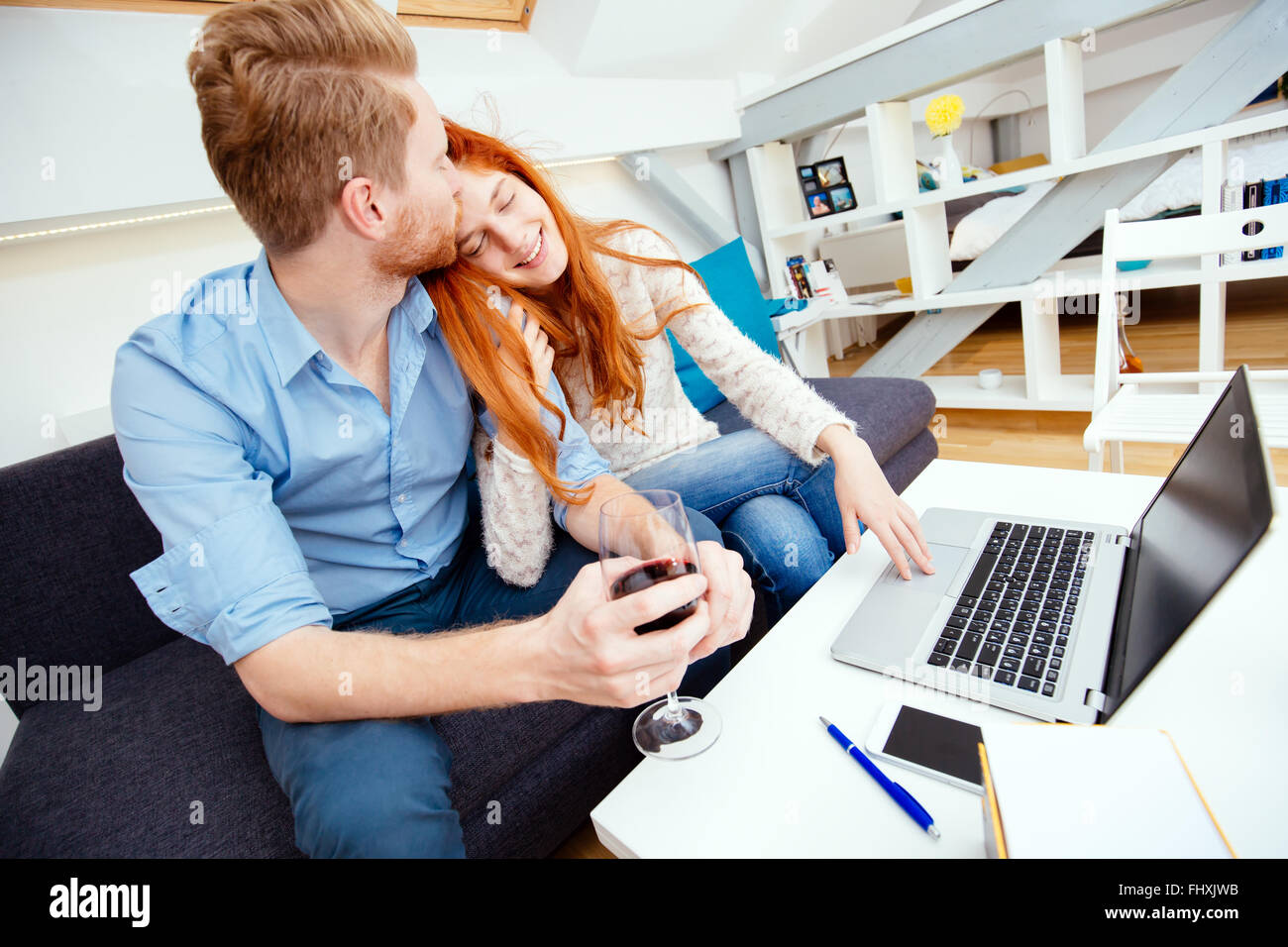 Beautiful couple working on laptop in beautiful living room while ...