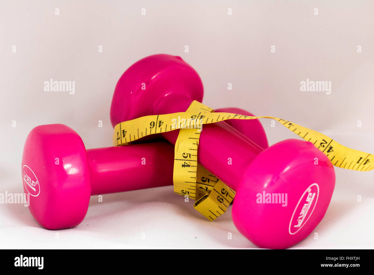 Pink dumbbells with measuring tape Stock Photo - Alamy