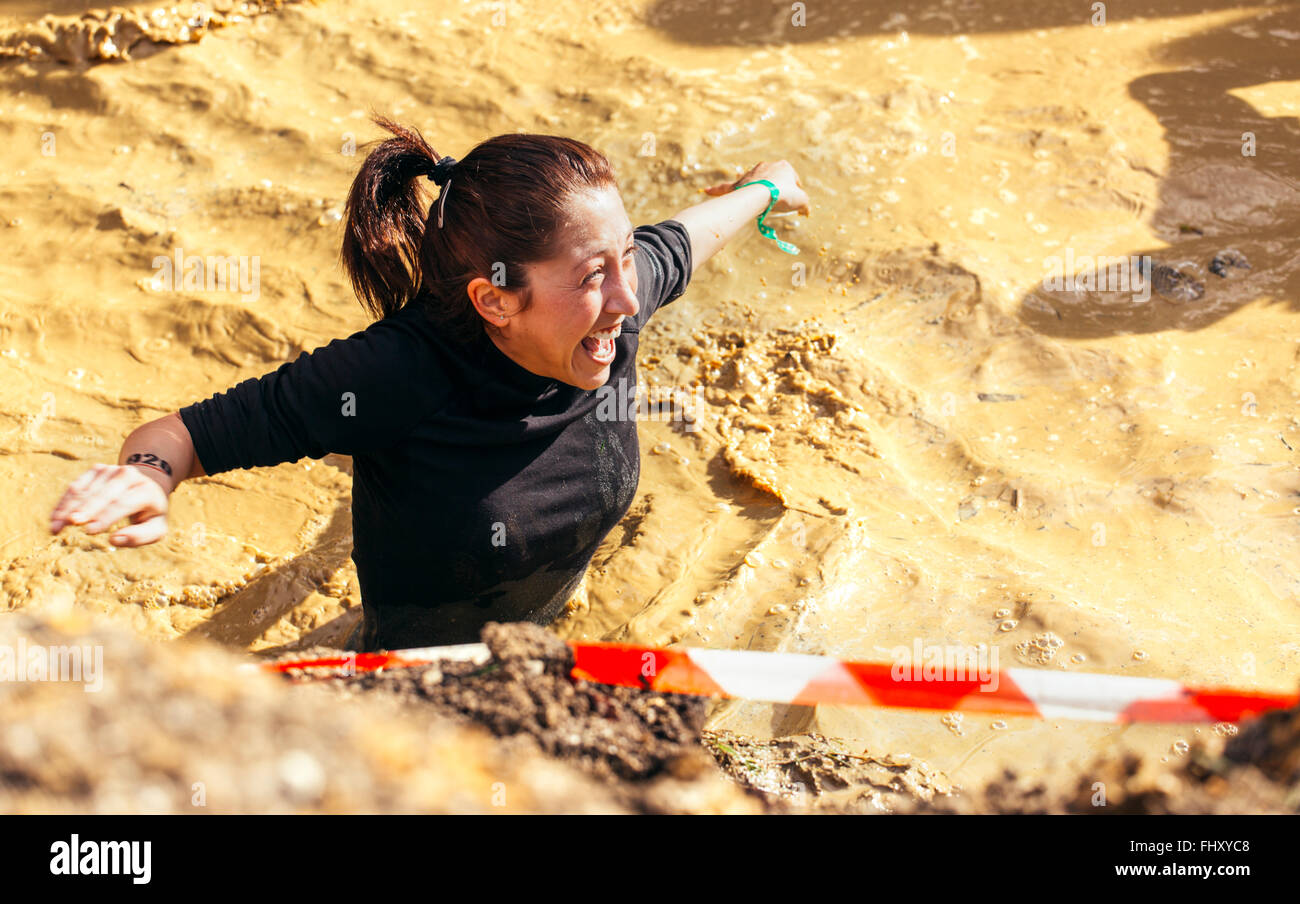 Participants in extreme obstacle race, running through mud Stock Photo ...