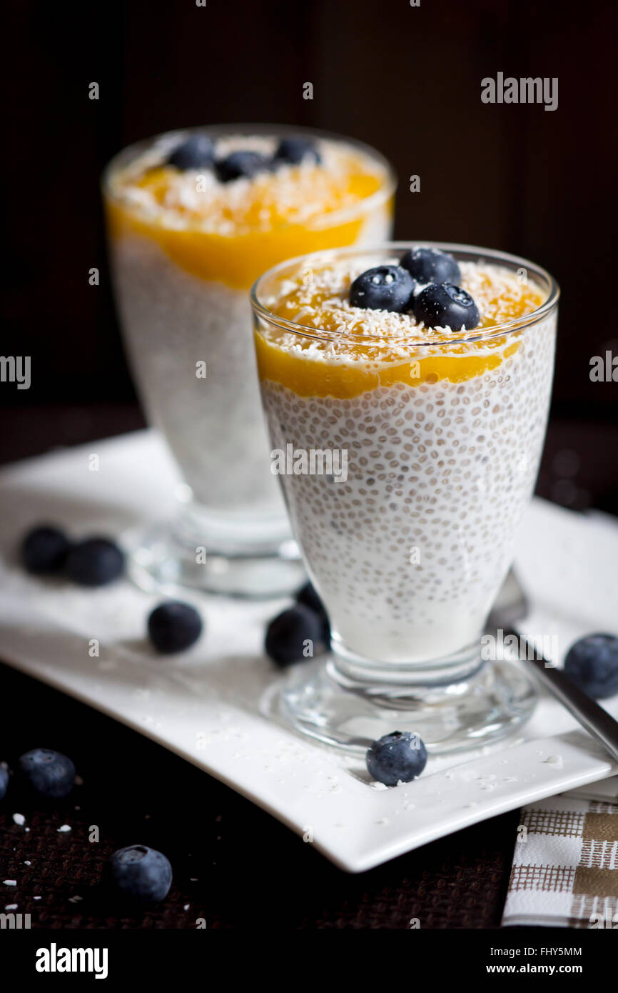 Two glasses of chia pudding with mango banana mush, blueberries and ...