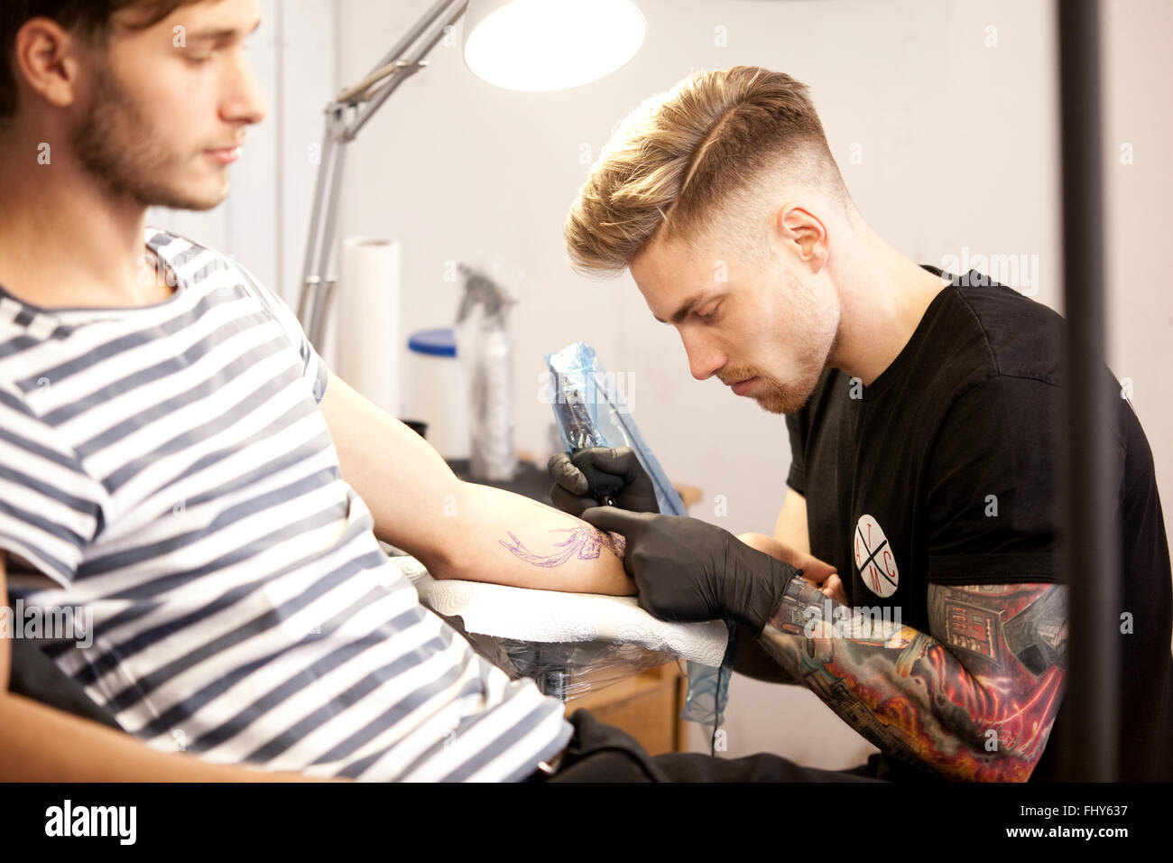 Tattooist at work in his tattoo studio Stock Photo - Alamy