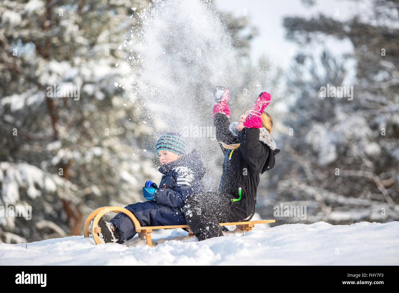 Two children sitting on a sledge Stock Photo - Alamy