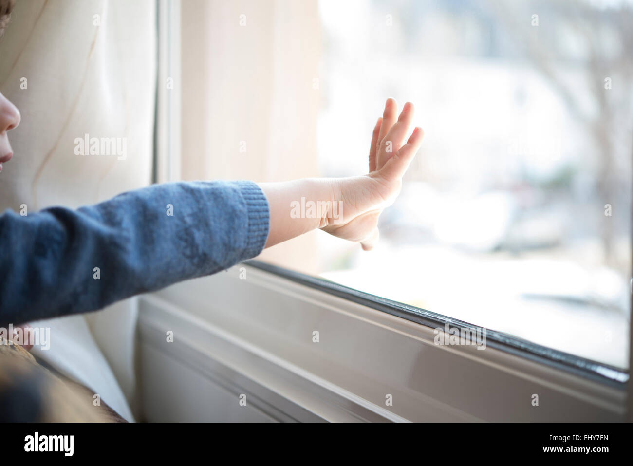 Hand of little boy touching windowpane Stock Photo - Alamy