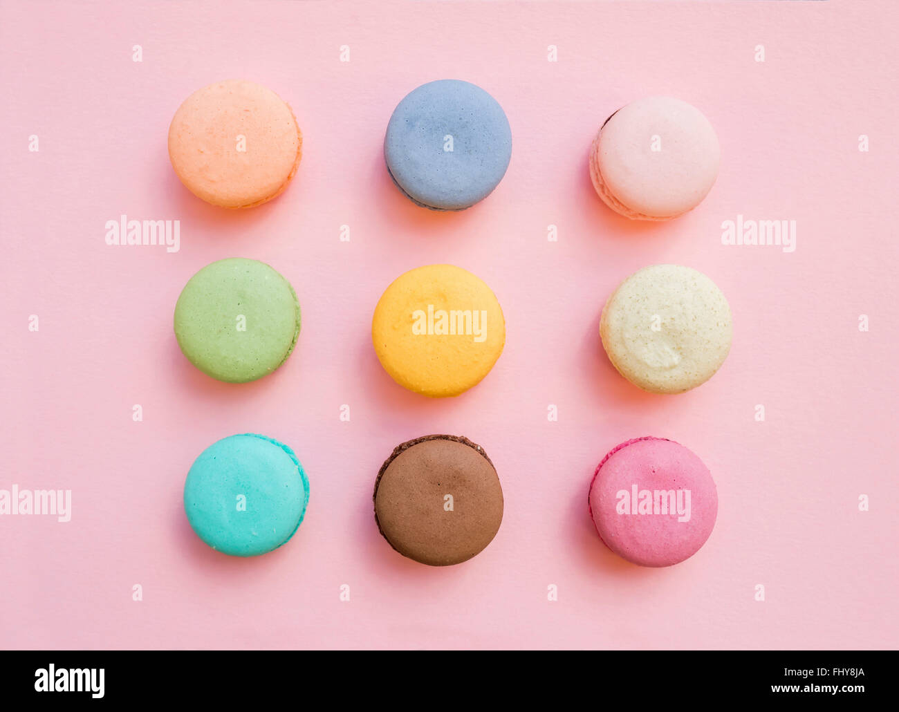 Sweet colorful French macaron biscuits on pastel pink background top ...