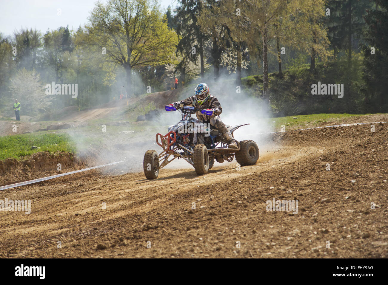 Racer is riding a quad with a smoking engine Stock Photo - Alamy