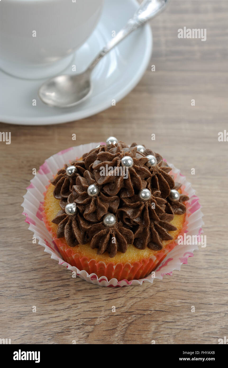 Muffin decorated with chocolate cream in paper packaging Stock Photo ...