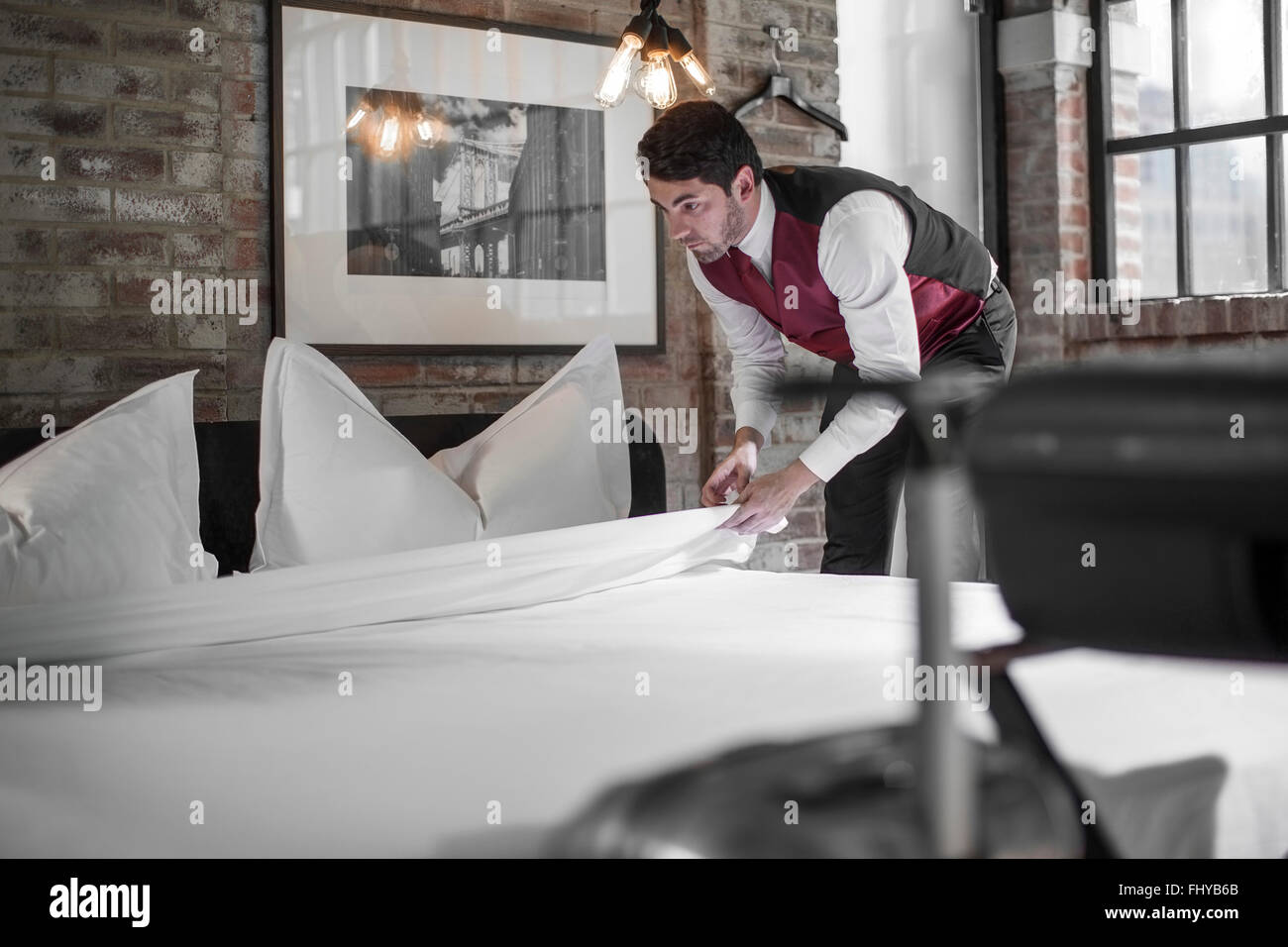 Housekeeper in hotel room, making the bed Stock Photo - Alamy