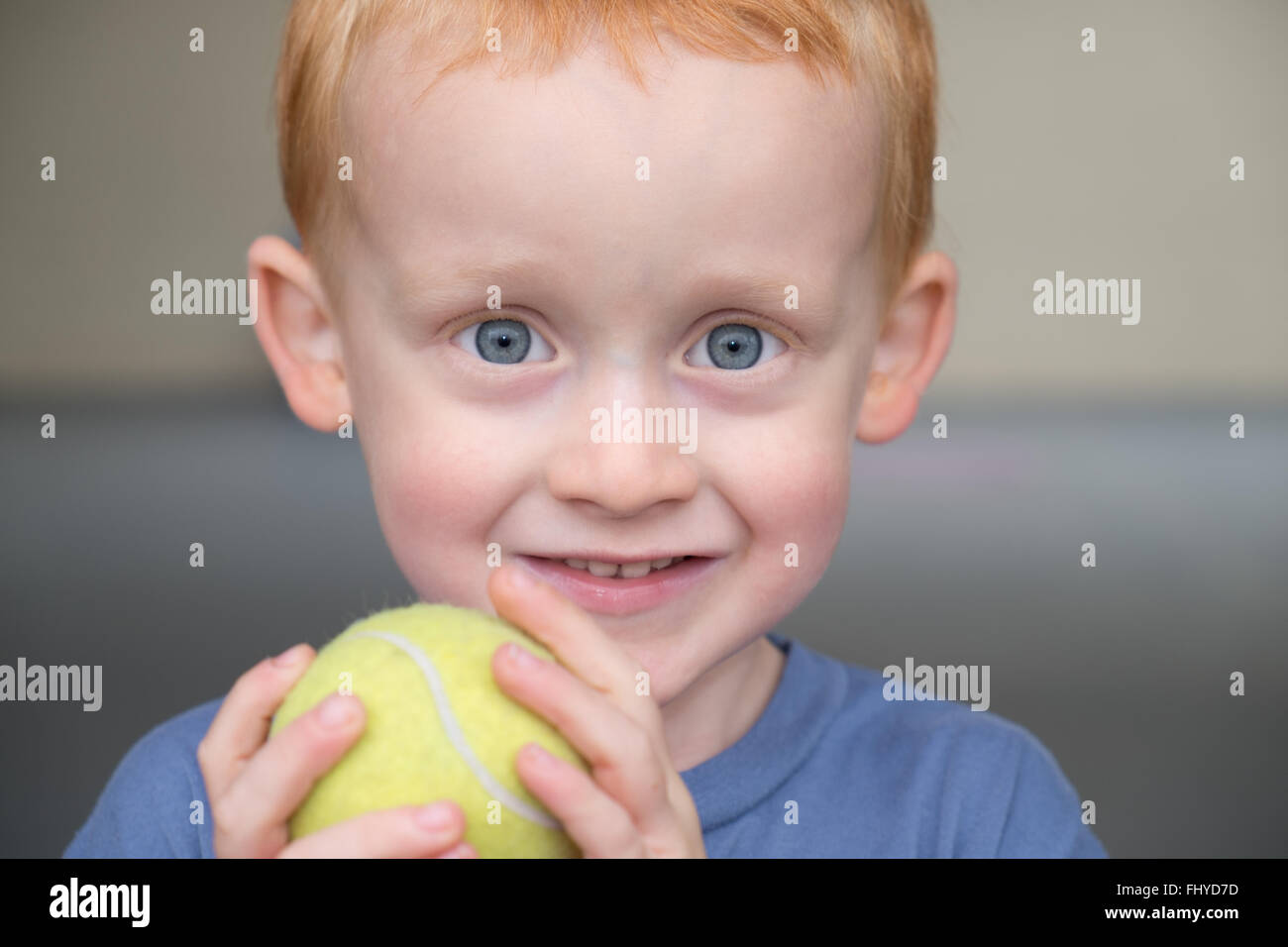 Red Haired, blue eyed Boy Close Up, smiling and holding a tennis ball ...