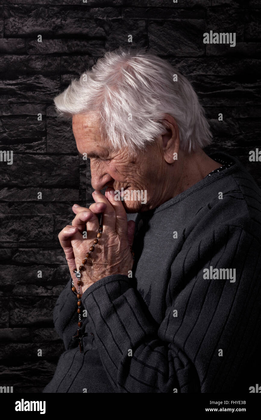 Grandmother praying. Old wrinkled beautiful woman praying with rosary ...
