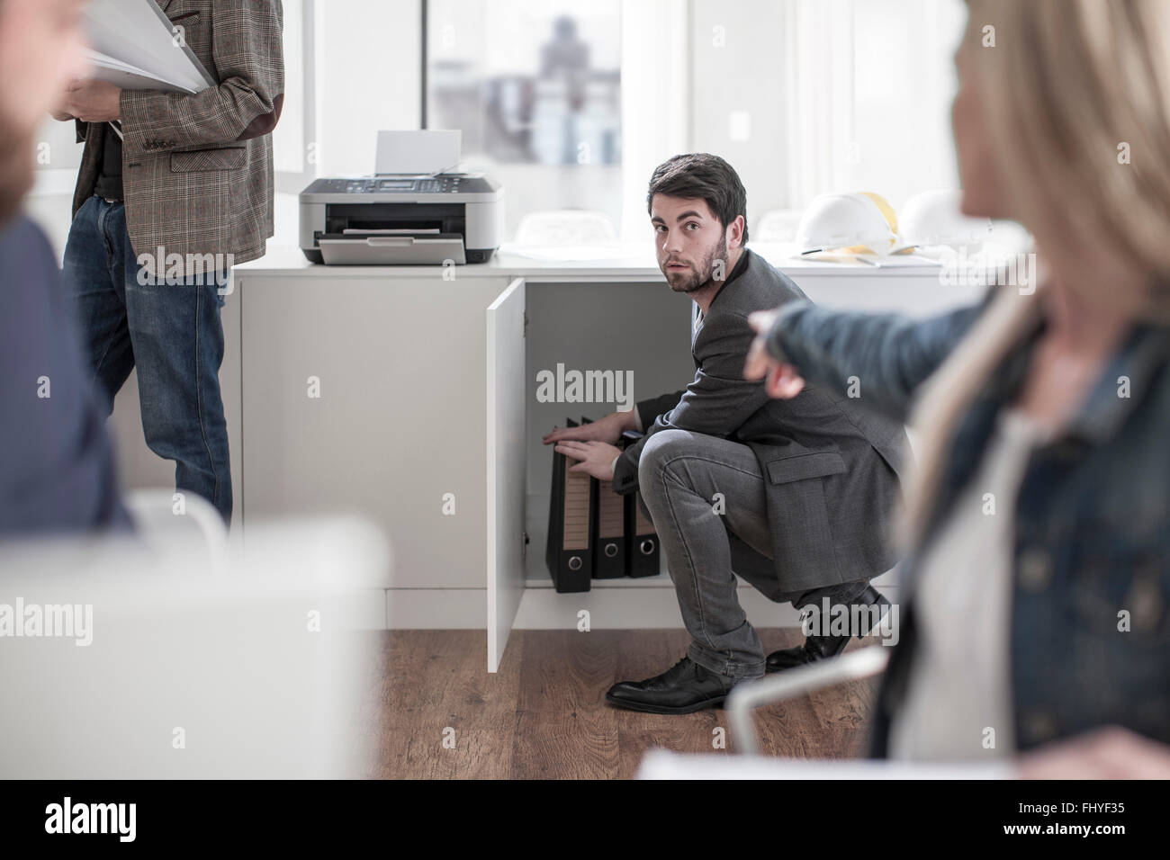 Man in office bringing folder to colleague Stock Photo - Alamy
