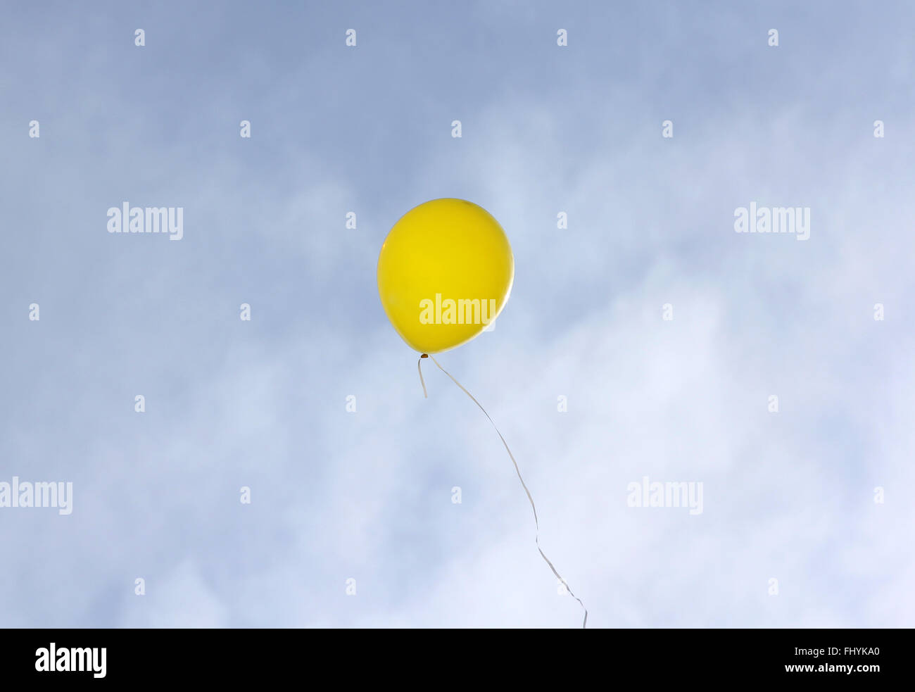 Yellow balloon flying on a blue sky background Stock Photo - Alamy