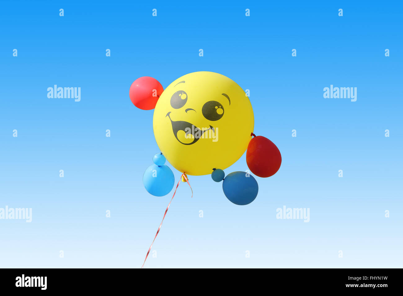 Yellow balloon flying on a blue sky background Stock Photo - Alamy