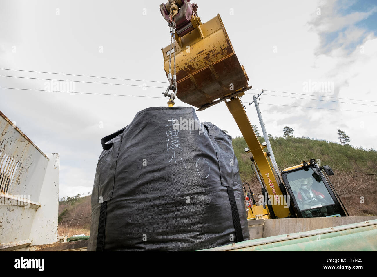 A bag containing irradiated debris is stacked on a truck in an area ...