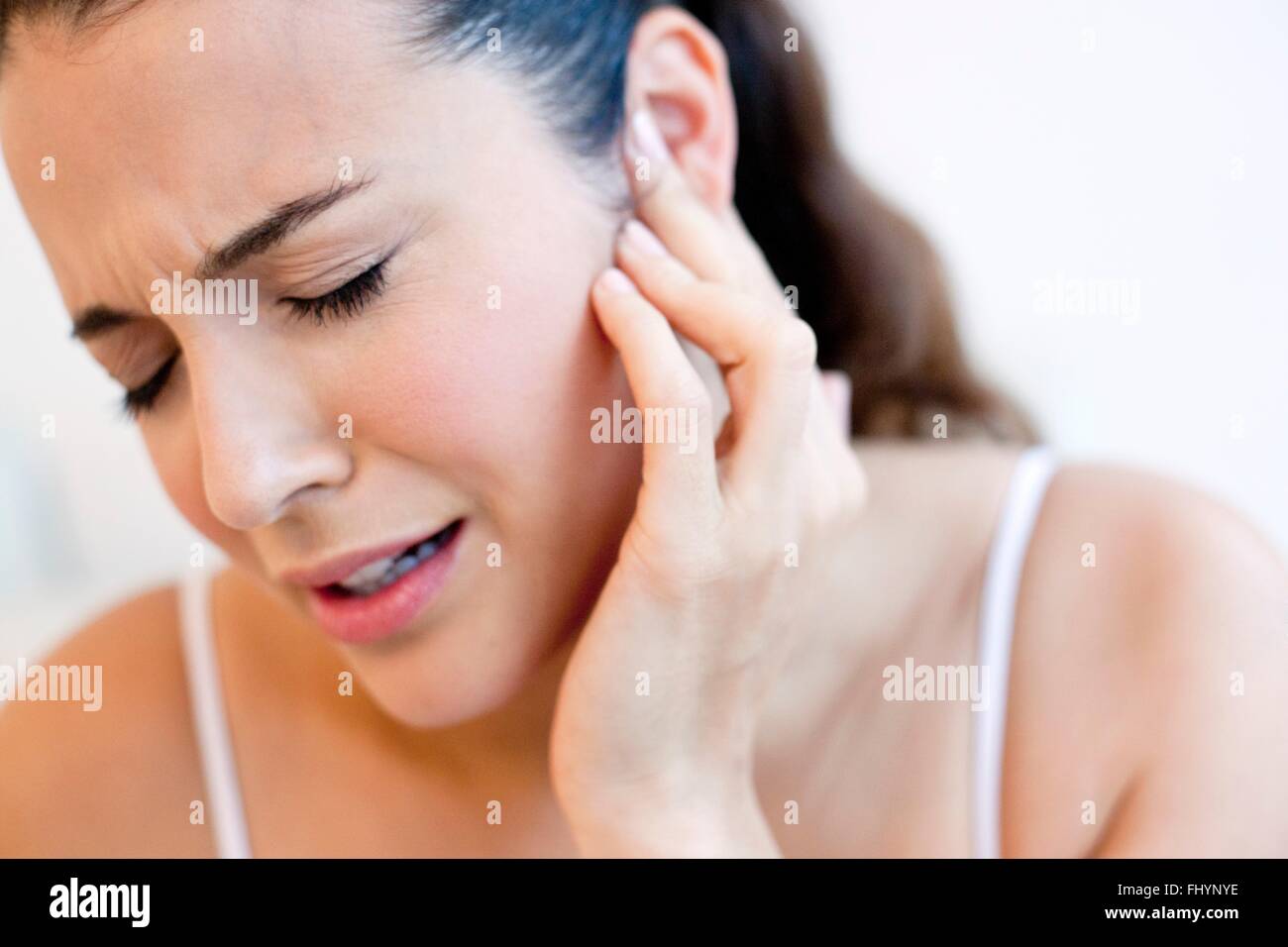MODEL RELEASED. Woman touching her ear with earache Stock Photo - Alamy