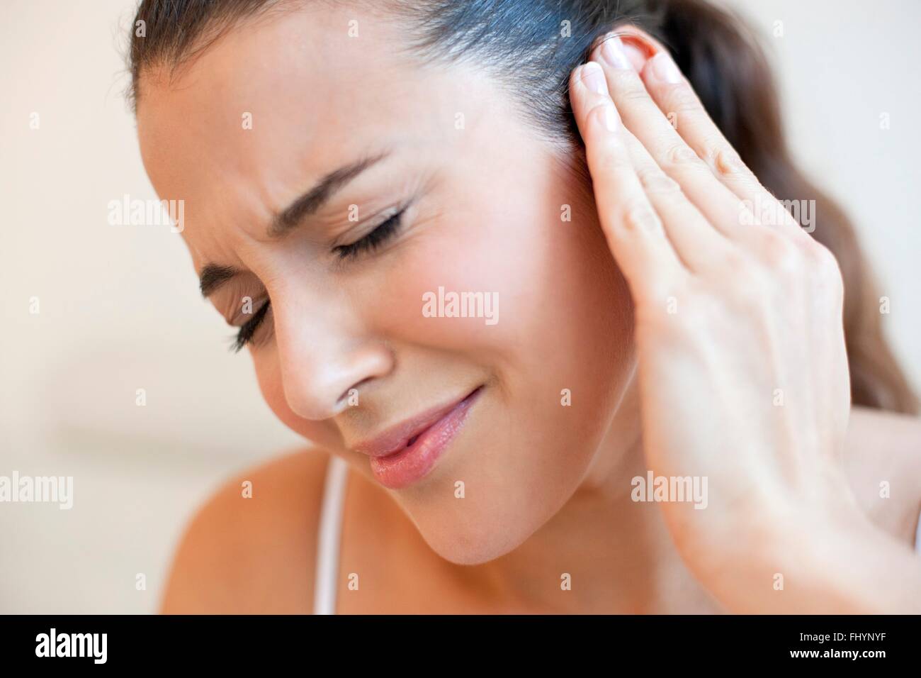 MODEL RELEASED. Woman touching her ear with earache Stock Photo - Alamy