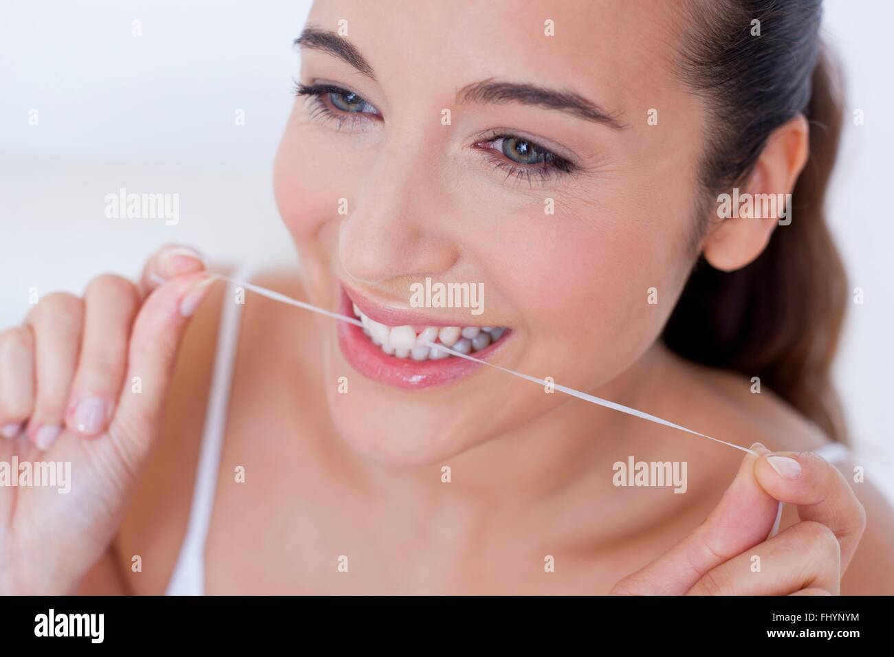 MODEL RELEASED. Woman flossing her teeth Stock Photo - Alamy