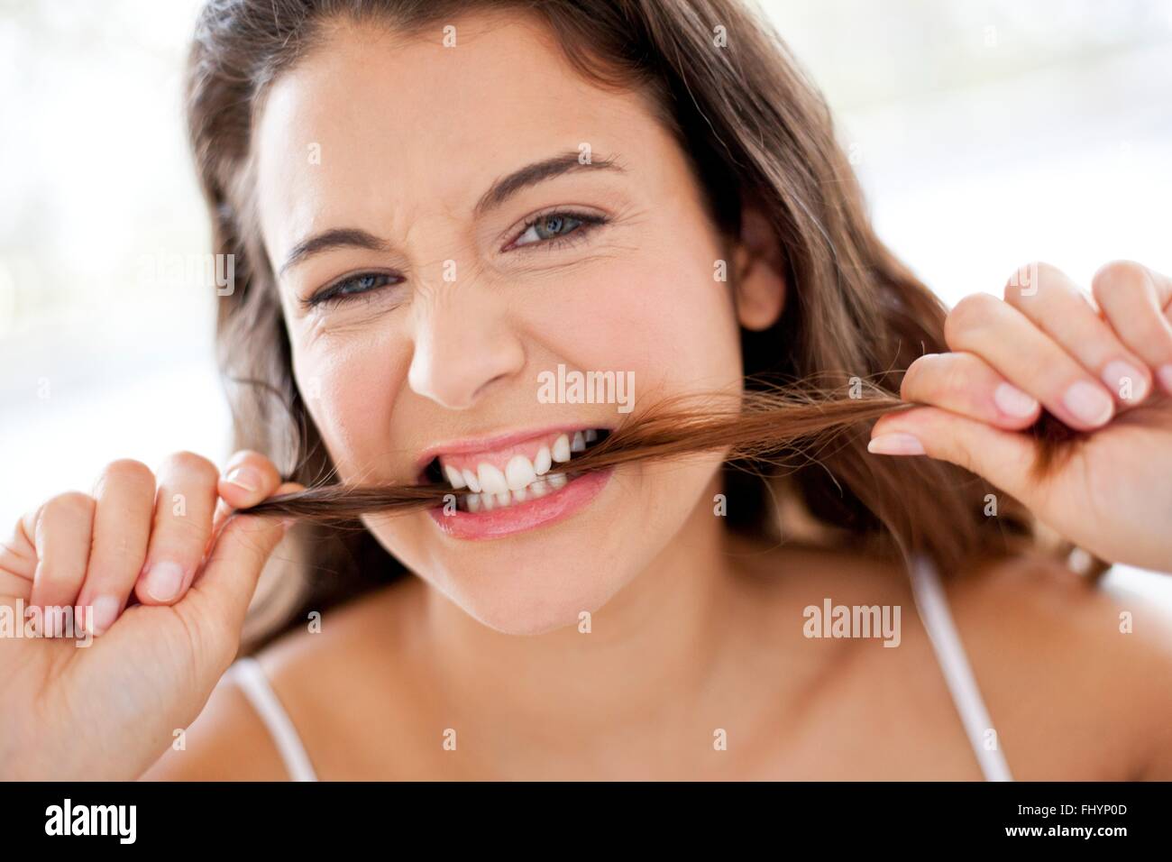 MODEL RELEASED. Woman biting her hair Stock Photo - Alamy