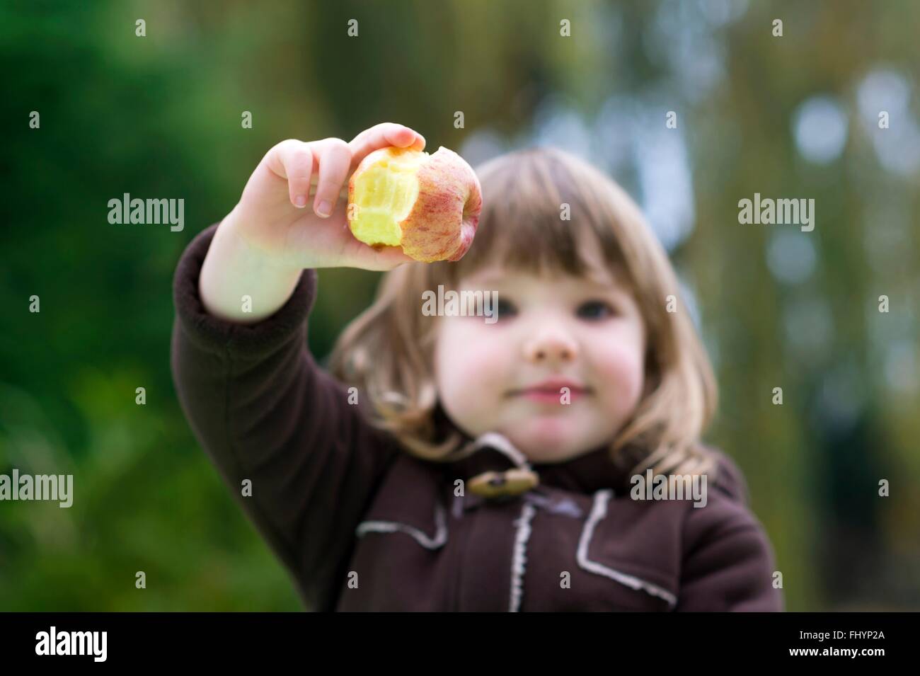 MODEL RELEASED. Young girl holding an apple Stock Photo - Alamy