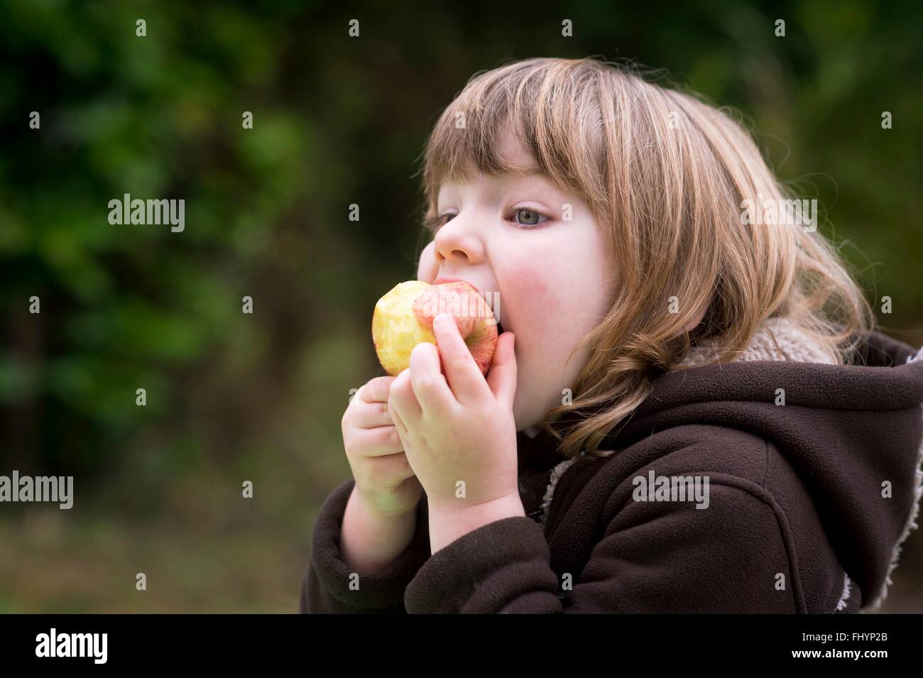MODEL RELEASED. Young girl eating an apple Stock Photo - Alamy