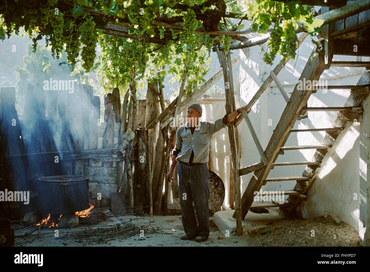 Turkish man tends the fire in his courtyard in the town of BEZIRGAN ...
